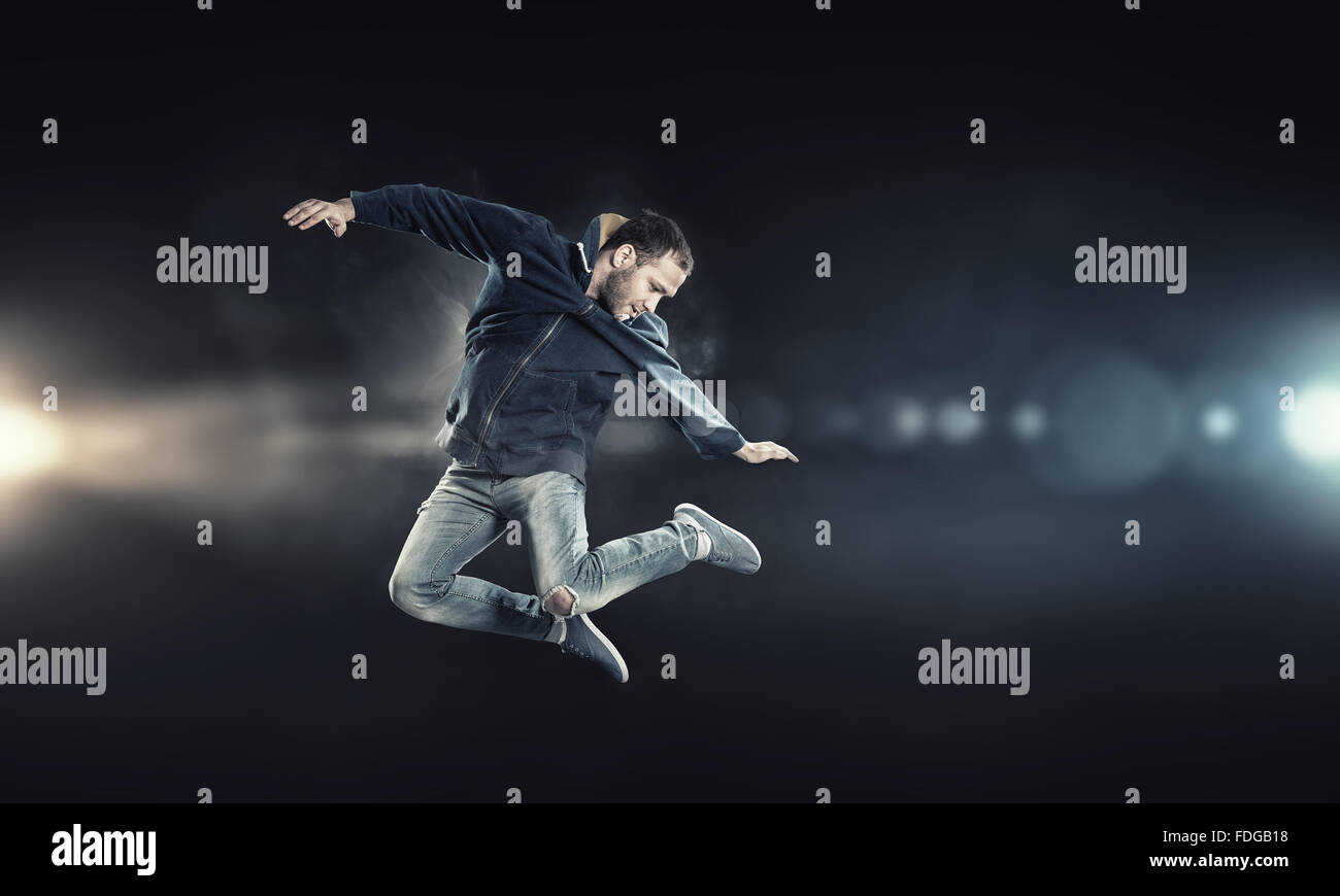 Modern style male dancer jumping in lights of spotlight Stock Photo - Alamy