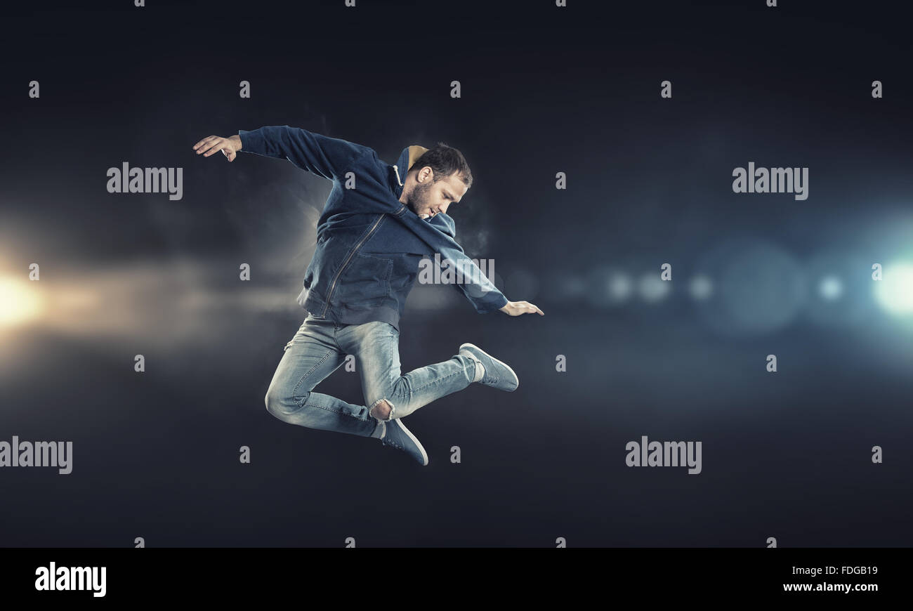 Modern style male dancer jumping in lights of spotlight Stock Photo - Alamy