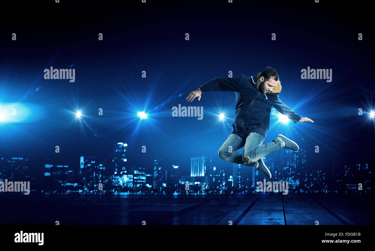 Modern style male dancer jumping in lights of spotlight Stock Photo - Alamy