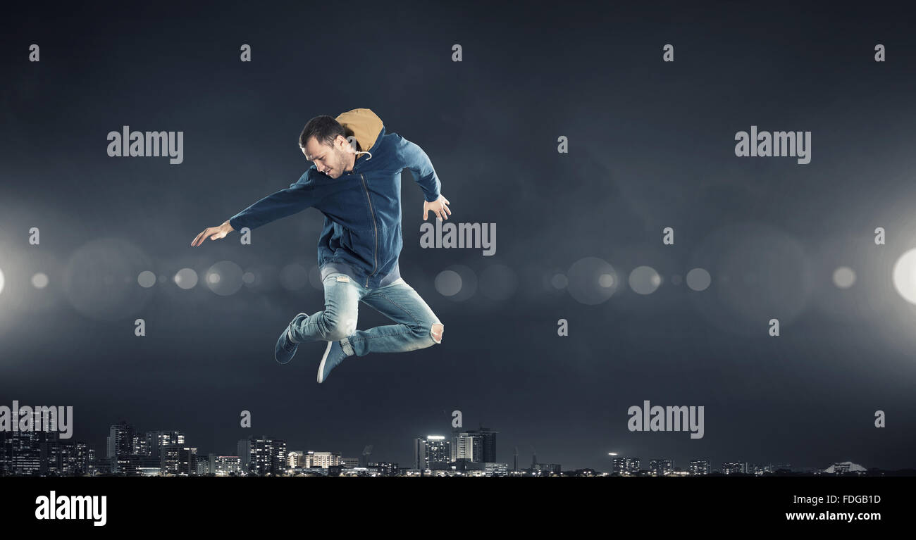 Modern style male dancer jumping in lights of spotlight Stock Photo - Alamy