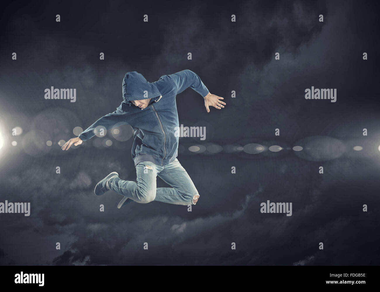 Modern style male dancer jumping in lights of spotlight Stock Photo - Alamy