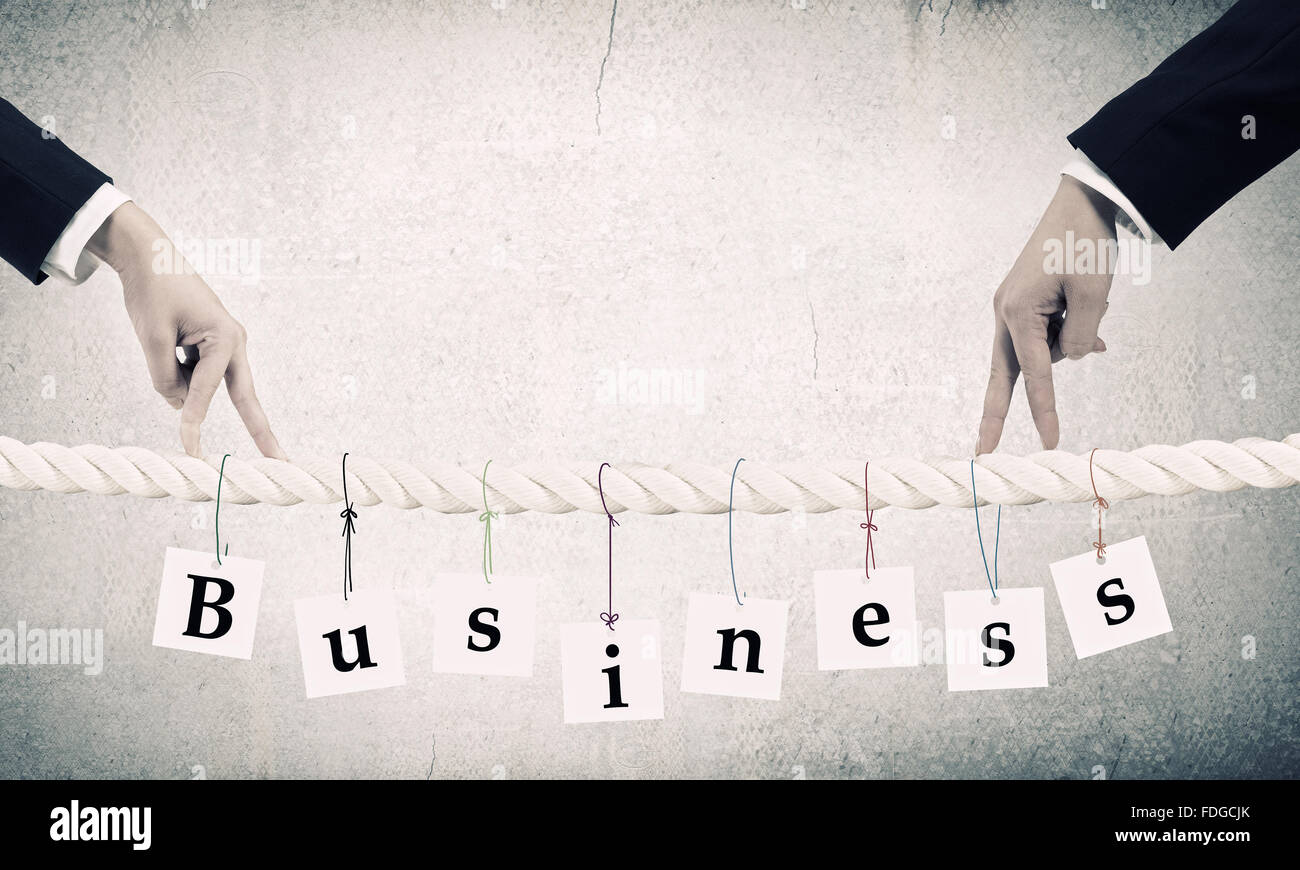 Close up of businessman hands walking with fingers on rope as ...