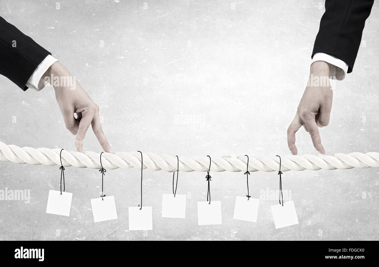 Close up of businessman hands walking with fingers on rope as ...