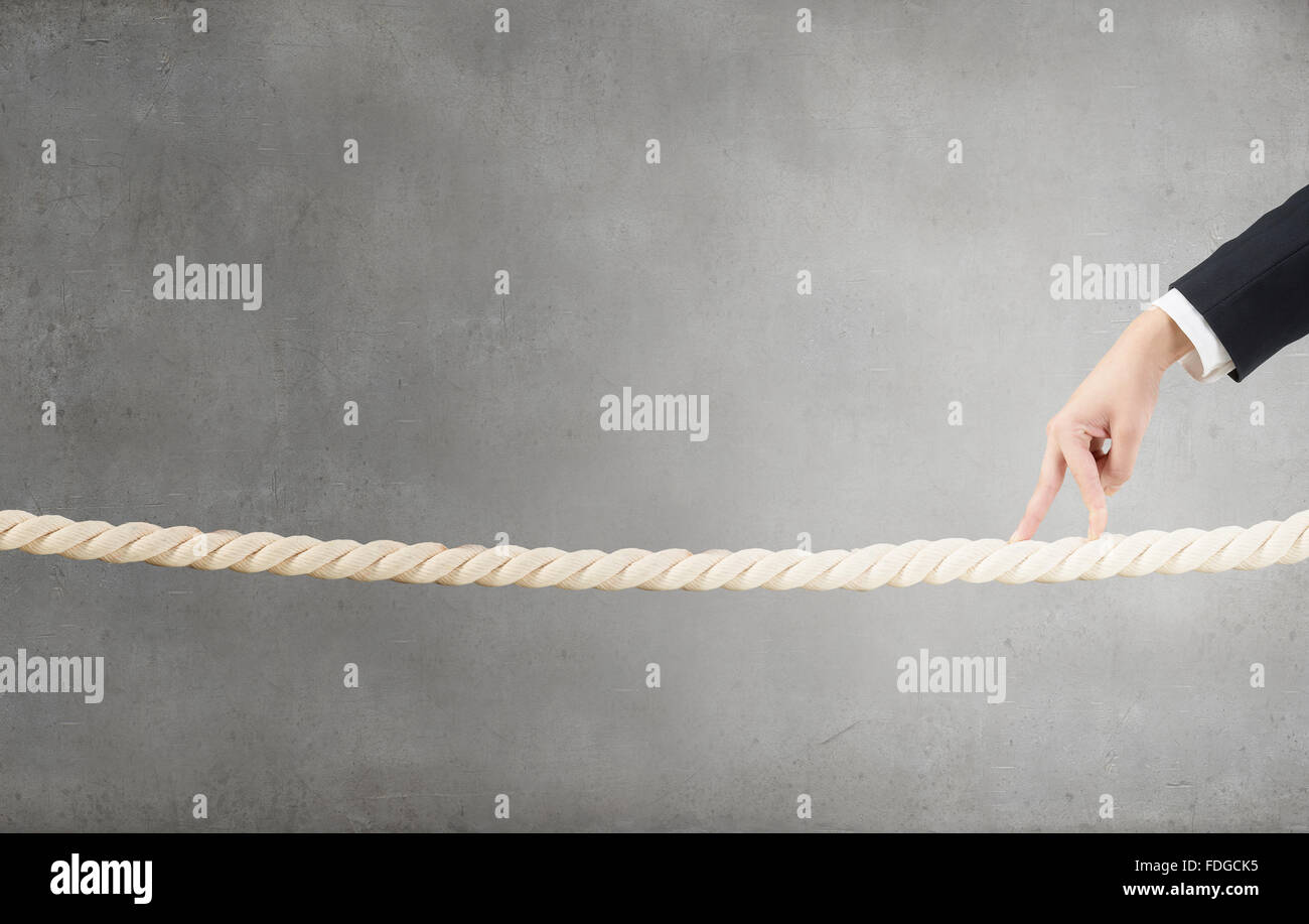Close up of businessman hands walking with fingers on rope as ...