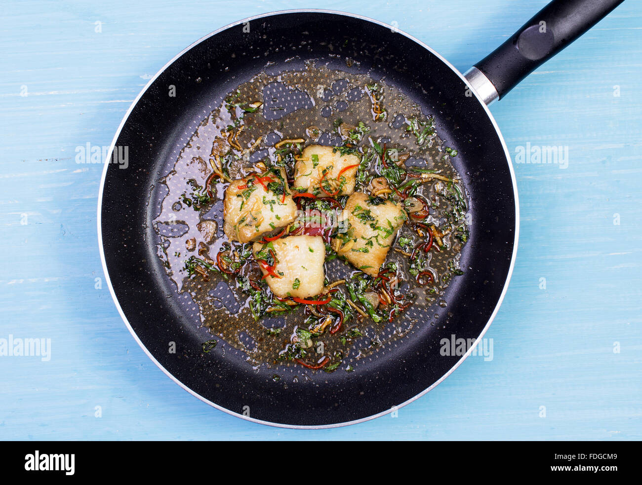 Frying pan with the leftovers of a fried fish Stock Photo - Alamy