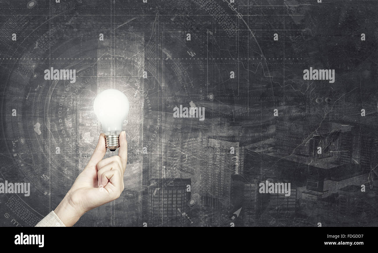 Human hand holding a shining electric bulb on digital background Stock ...