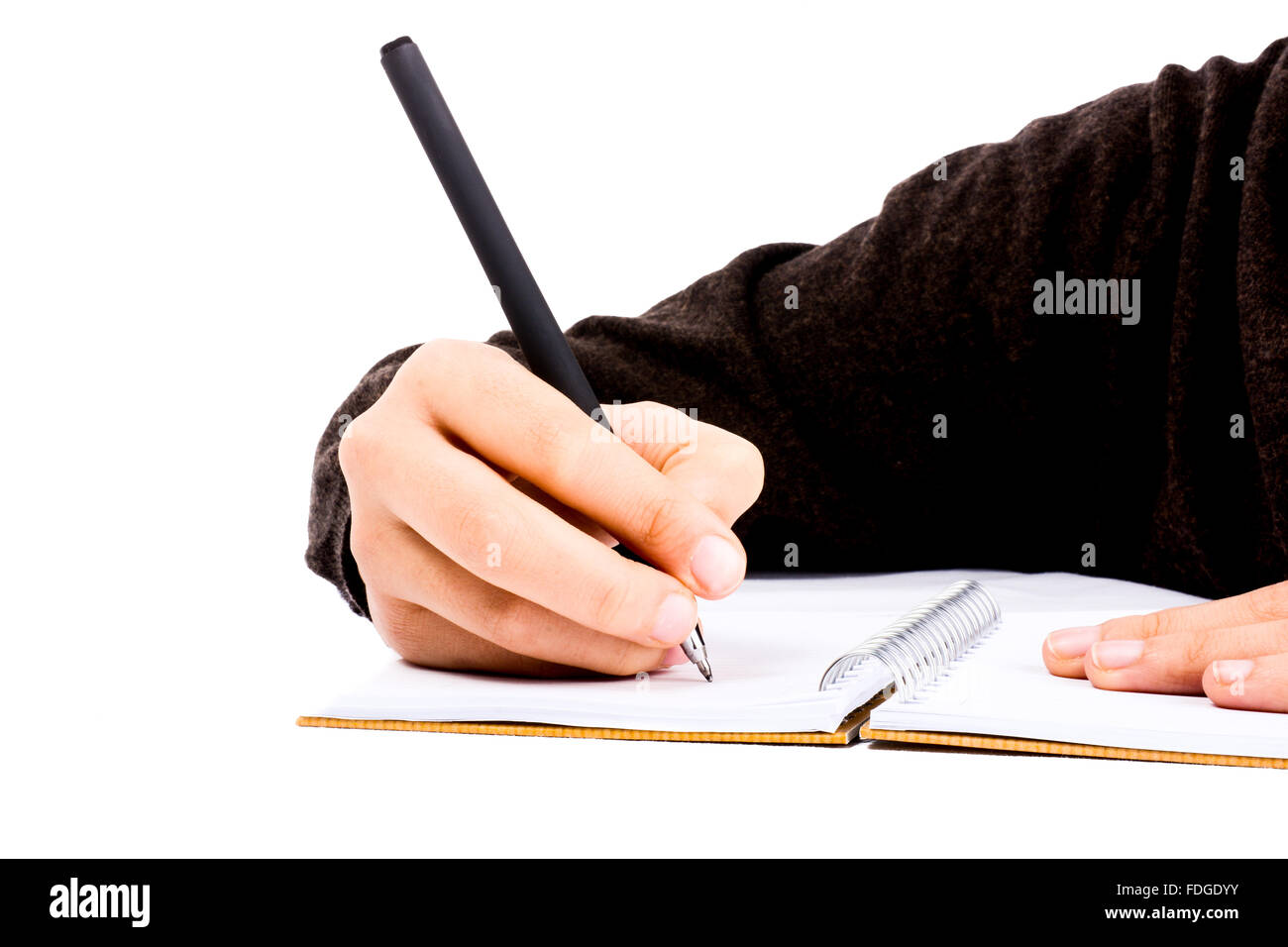 A child hand is writing with pen on a spiral notebook on white ...
