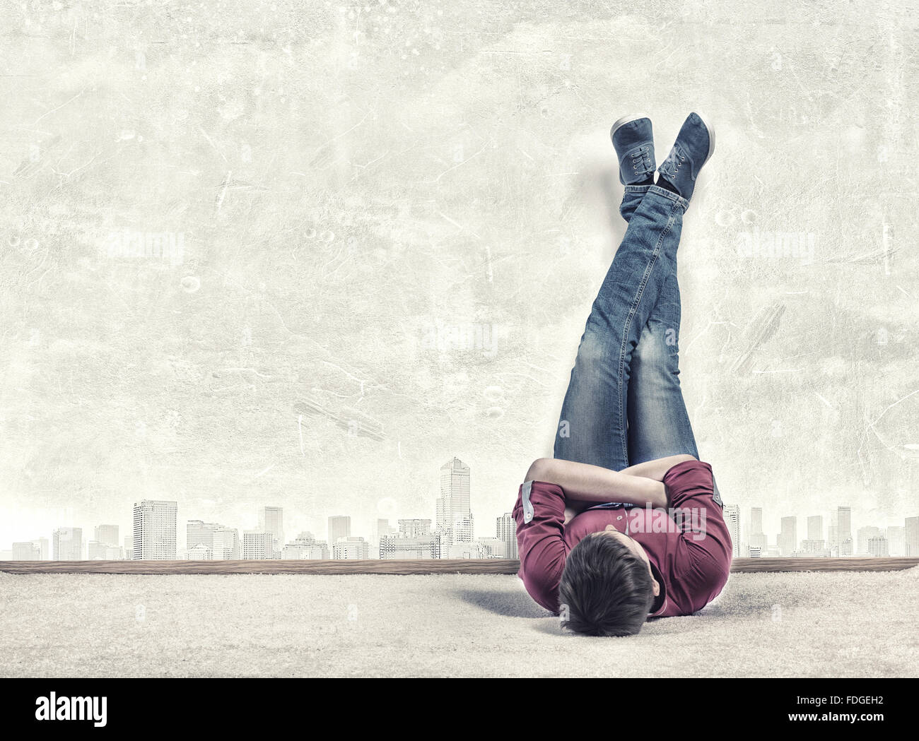 Young man lying on floor with legs raised up Stock Photo - Alamy