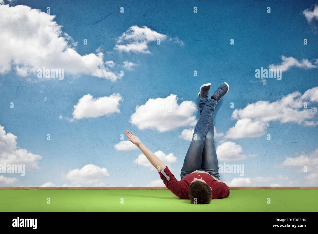 Young man lying on floor with legs raised up Stock Photo - Alamy