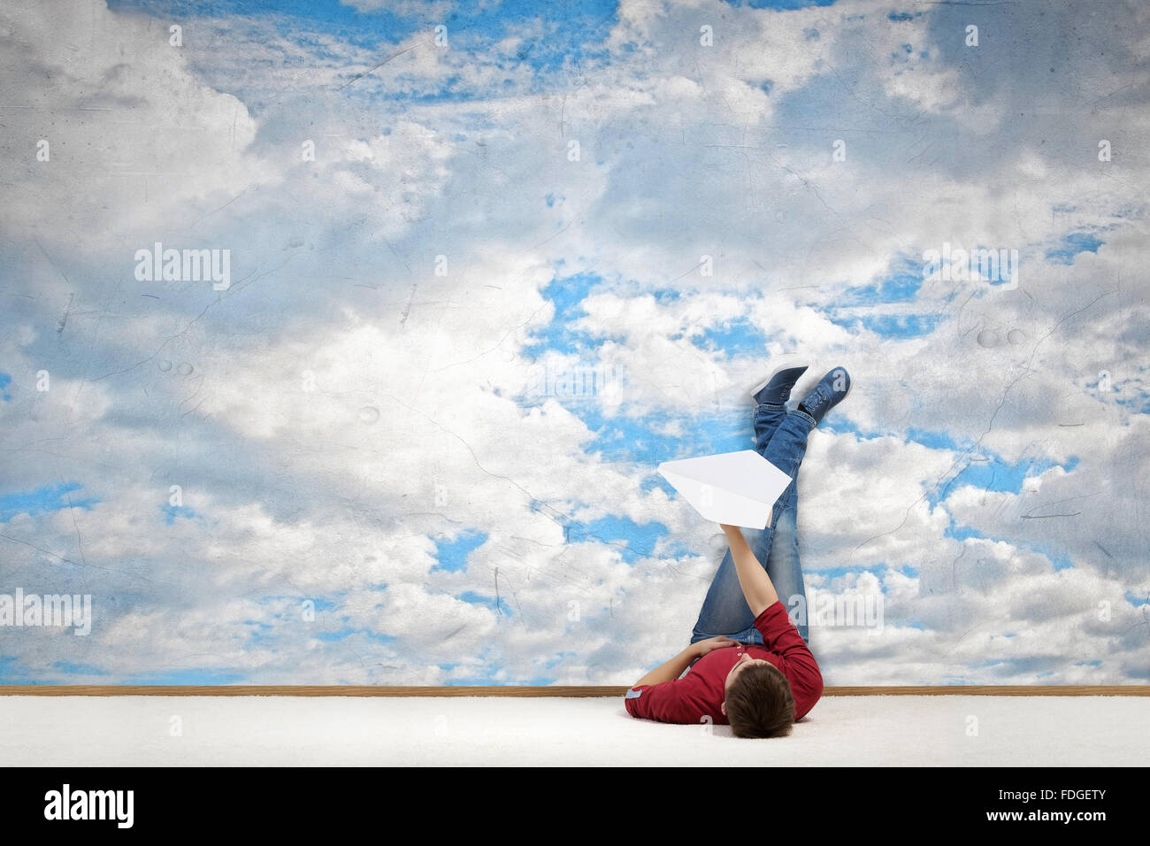 Young man lying on floor with legs raised up Stock Photo - Alamy