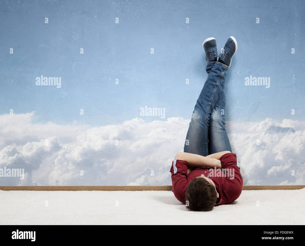 Young man lying on floor with legs raised up Stock Photo - Alamy