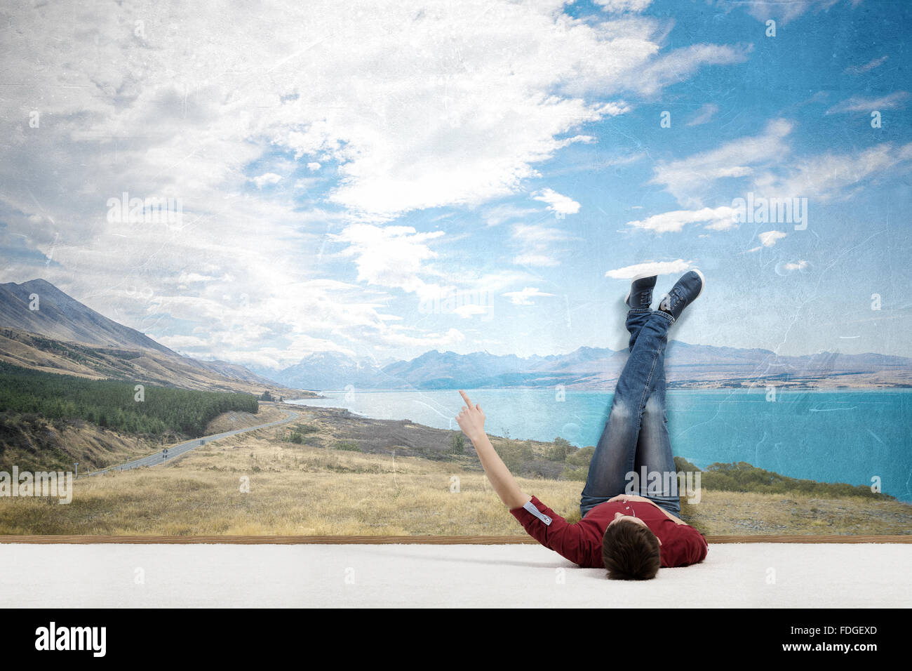 Young man lying on floor with legs raised up Stock Photo - Alamy