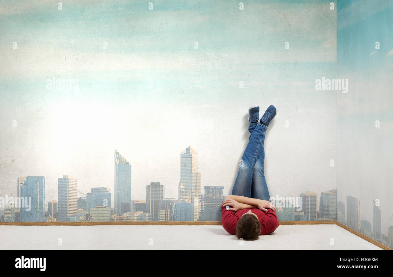 Young man lying on floor with legs raised up Stock Photo - Alamy
