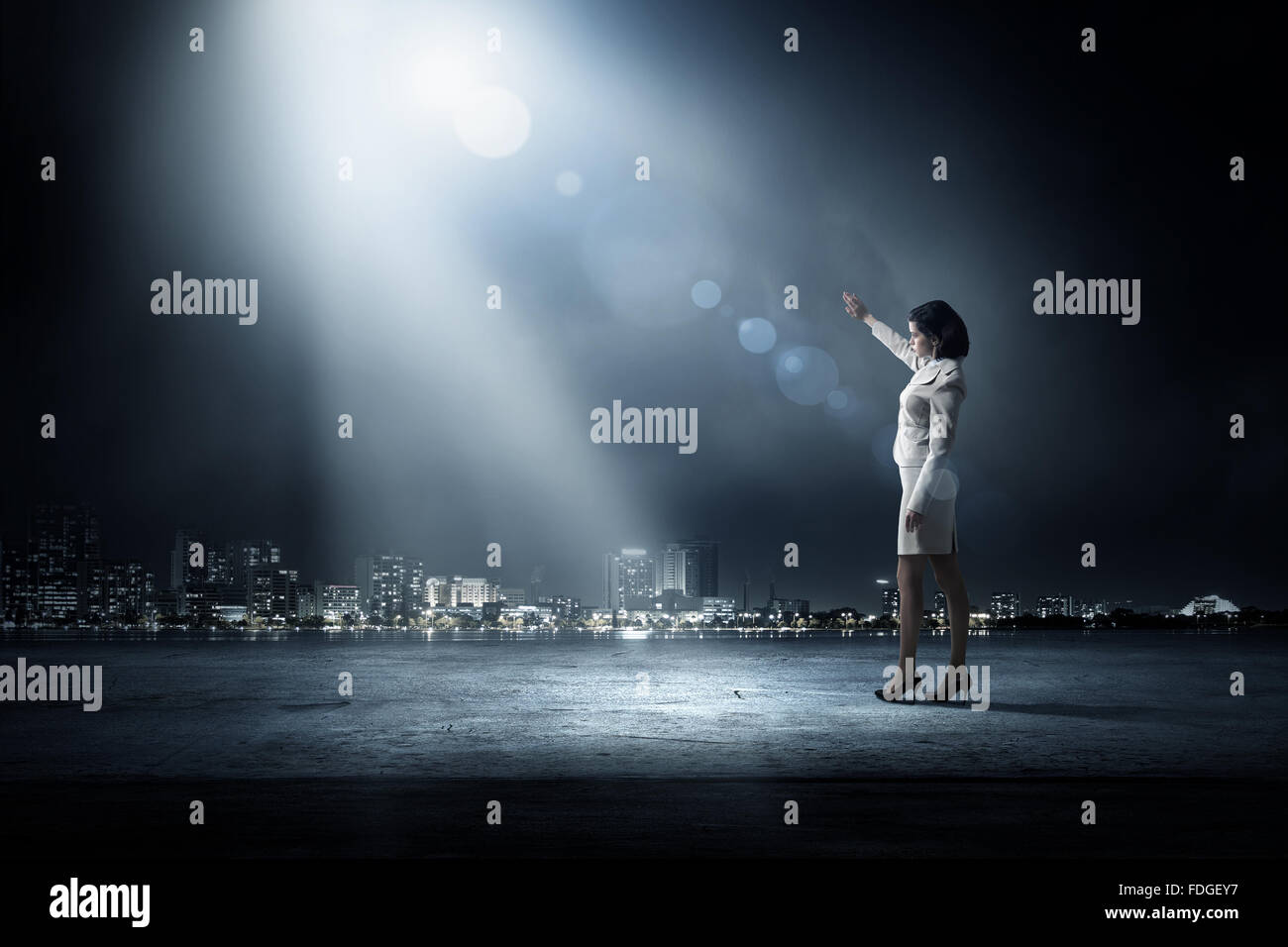 Young businesswoman blinded with light going from above Stock Photo - Alamy
