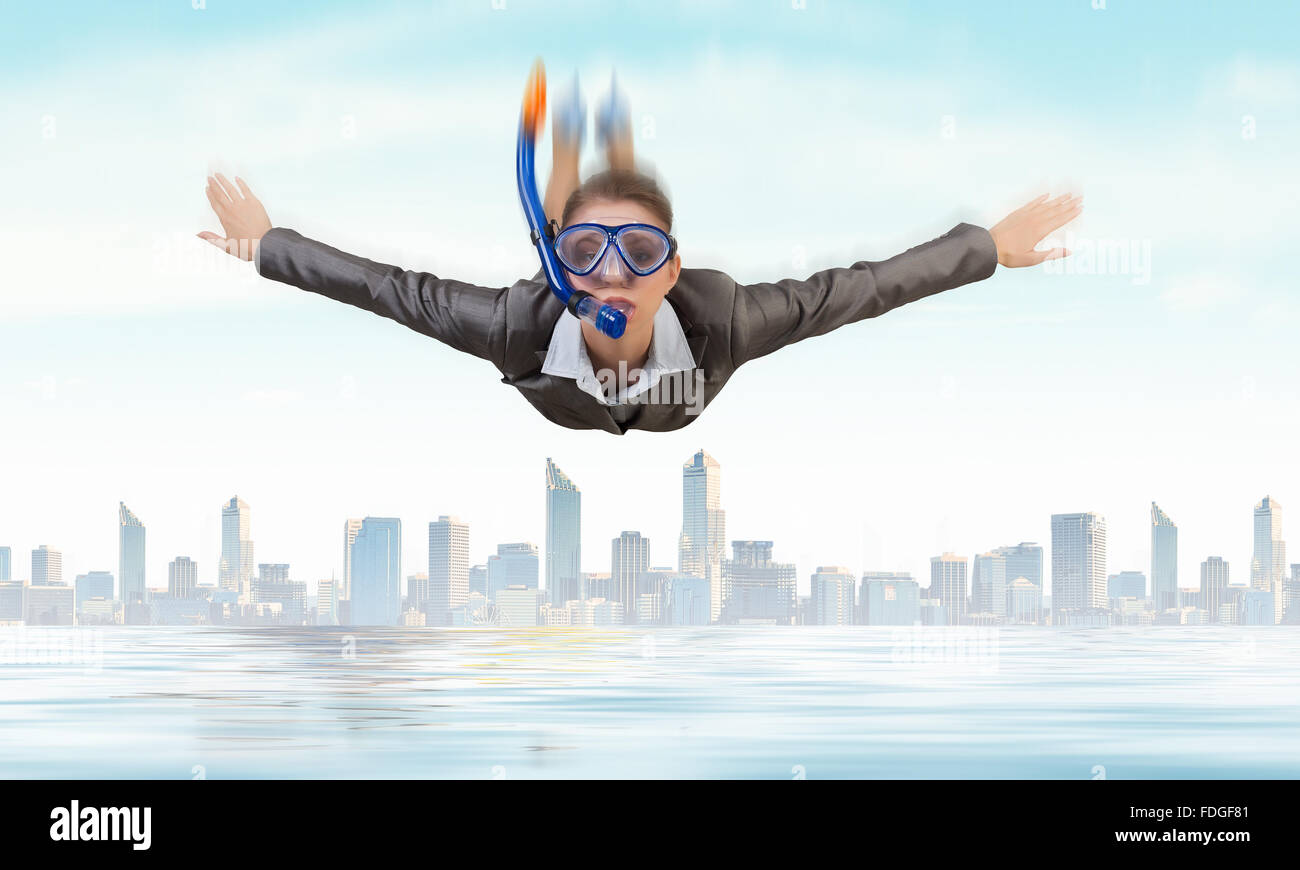 Young businesswoman in suit and diving mask flying in sky Stock Photo ...