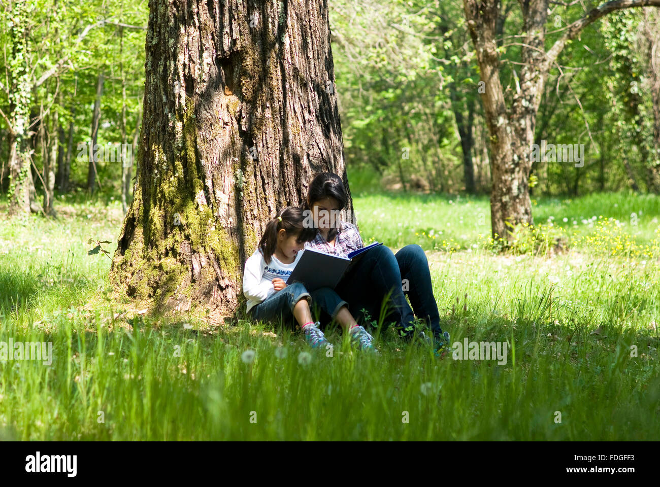 Child reading under a tree hi-res stock photography and images - Alamy