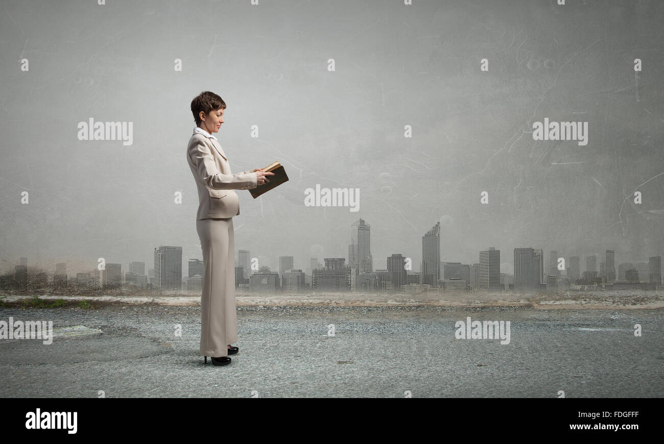 Adult woman in suit with old book in hand Stock Photo - Alamy