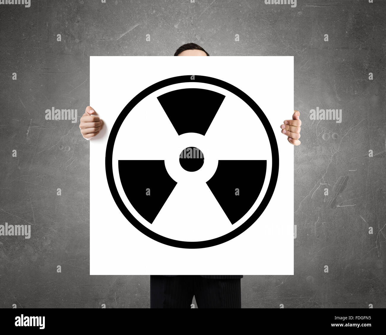 Businessman showing white banner with radioactive sign Stock Photo - Alamy