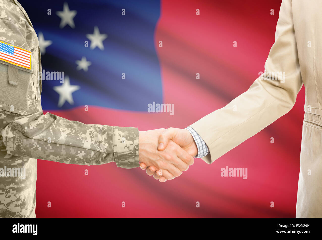 American soldier in uniform and civil man in suit shaking hands with ...