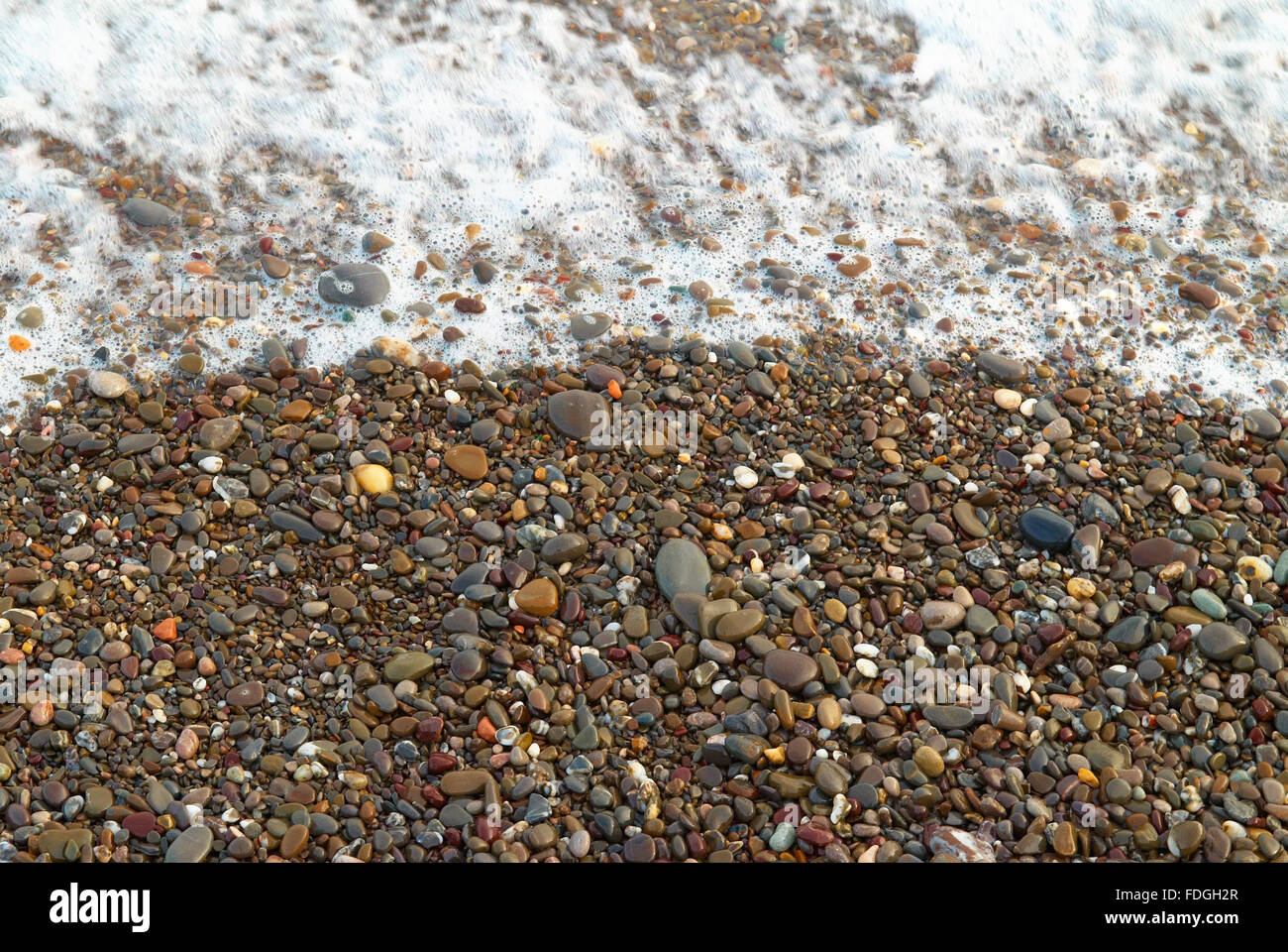 Wave, foam and textured stones Stock Photo - Alamy