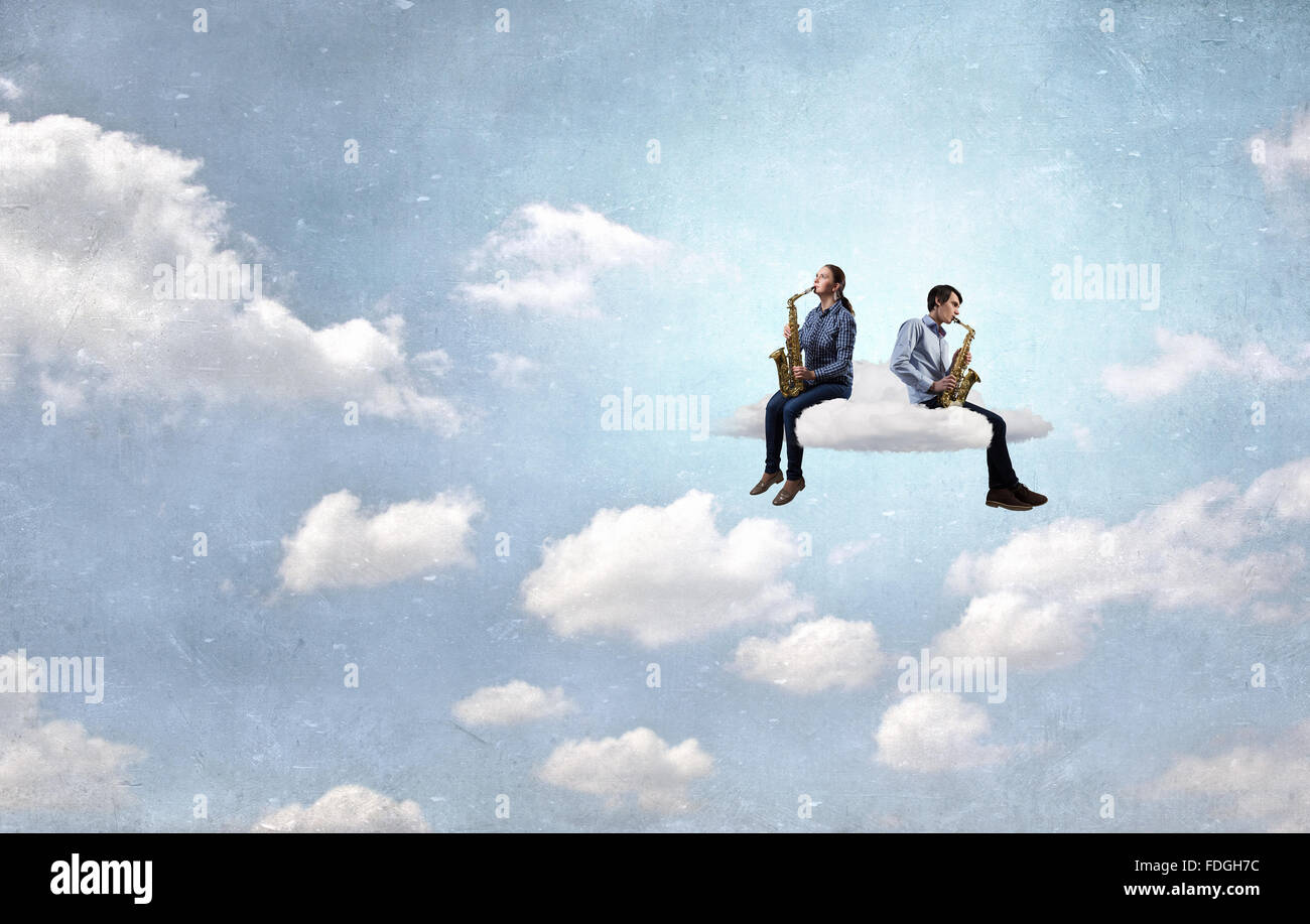 Duet of young man and woman musicians playing saxophones hi-res stock ...