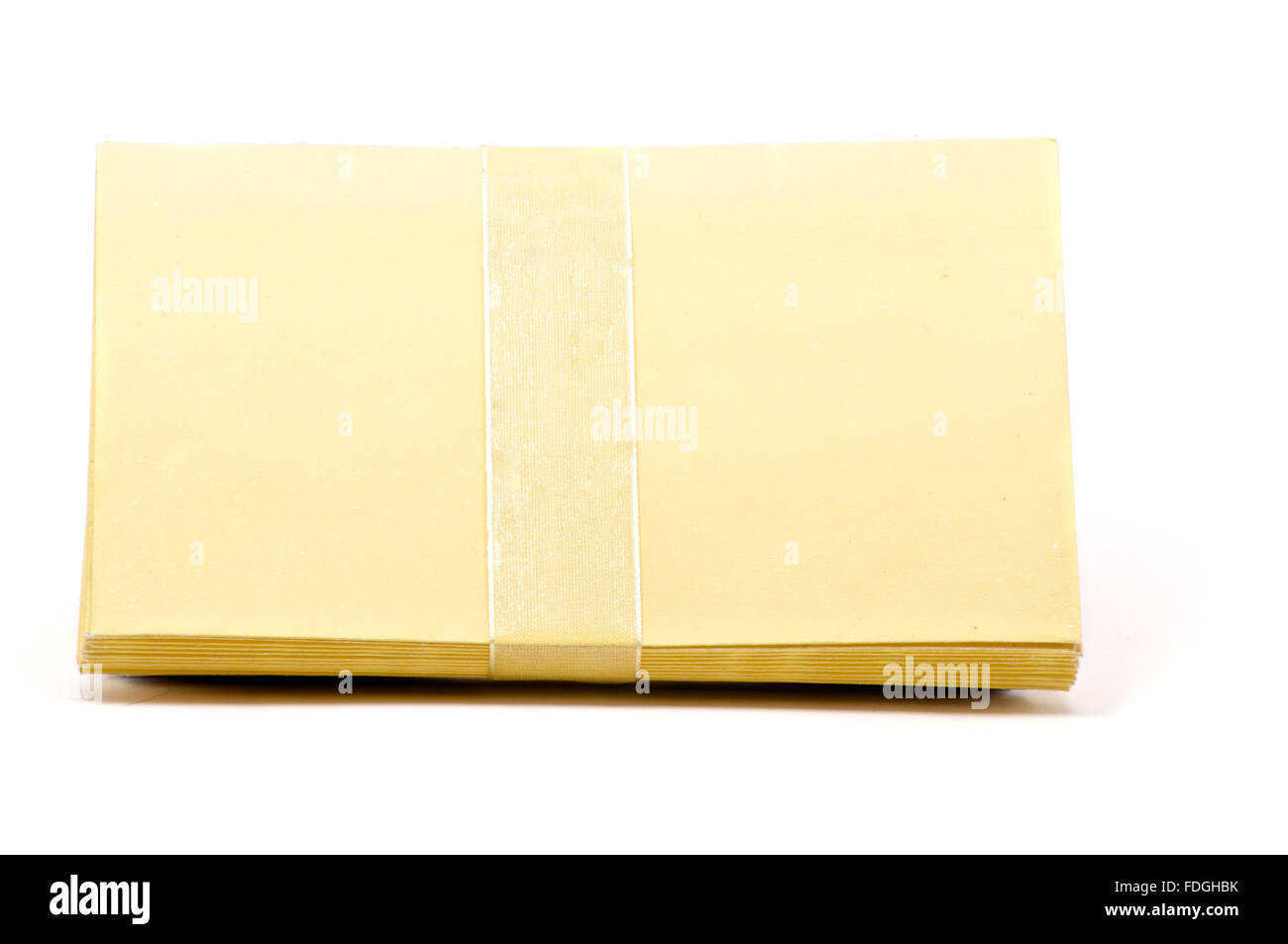Stack of yellow greeting cards with ribbon over white Stock Photo - Alamy