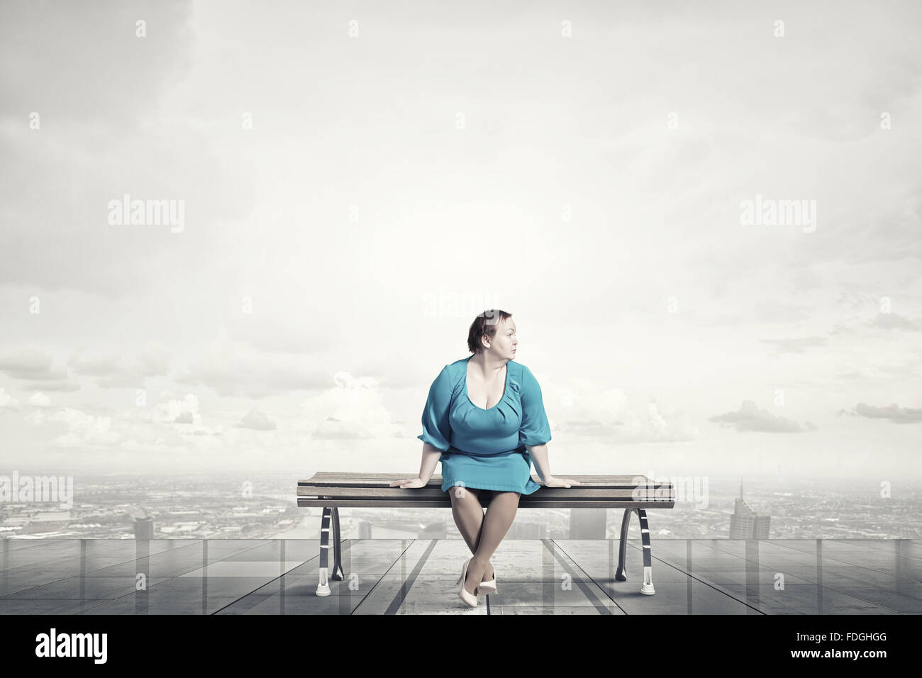 Middle aged stout woman in blue dress sitting on bench Stock Photo - Alamy