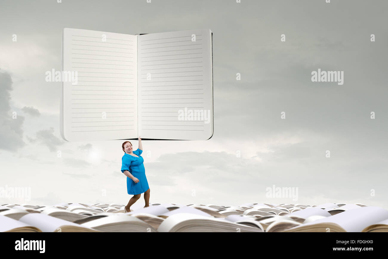 Middle aged stout woman in blue dress holding huge notepad Stock Photo ...