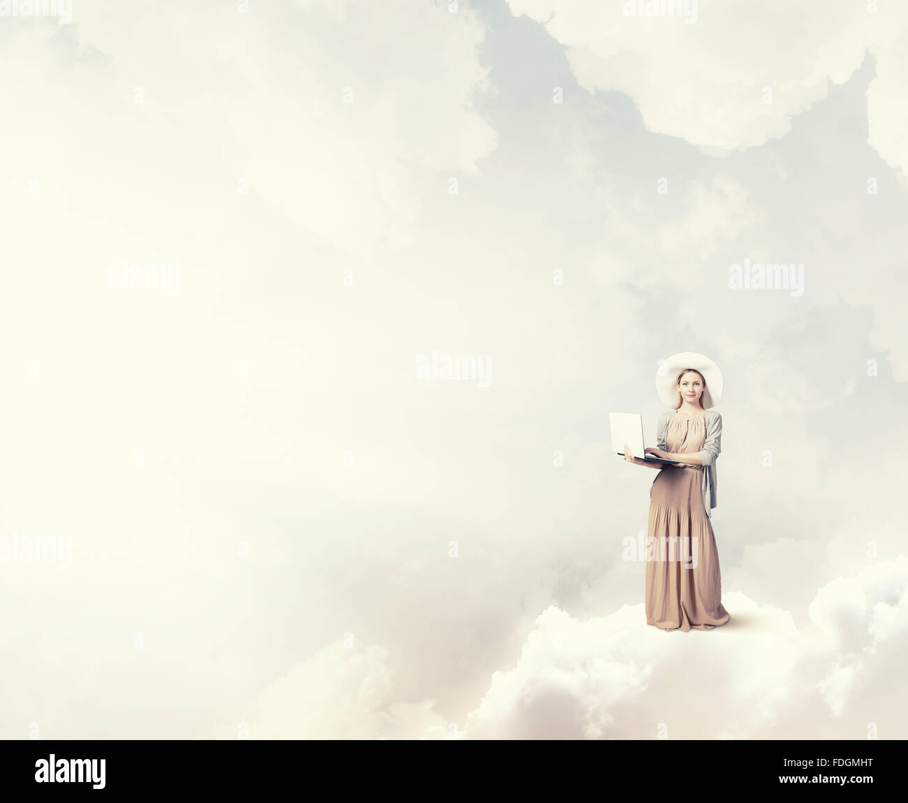 Young lady in hat and long dress using laptop hi-res stock photography ...