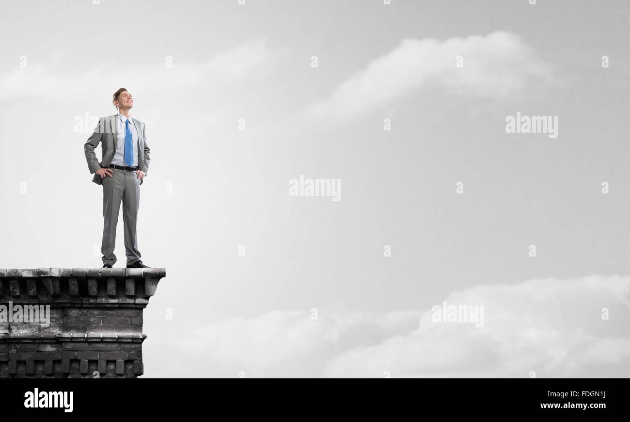 Young confident businessman standing on top of building Stock Photo - Alamy