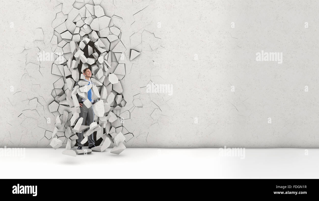 Young powerful businessman breaking through cement wall Stock Photo - Alamy