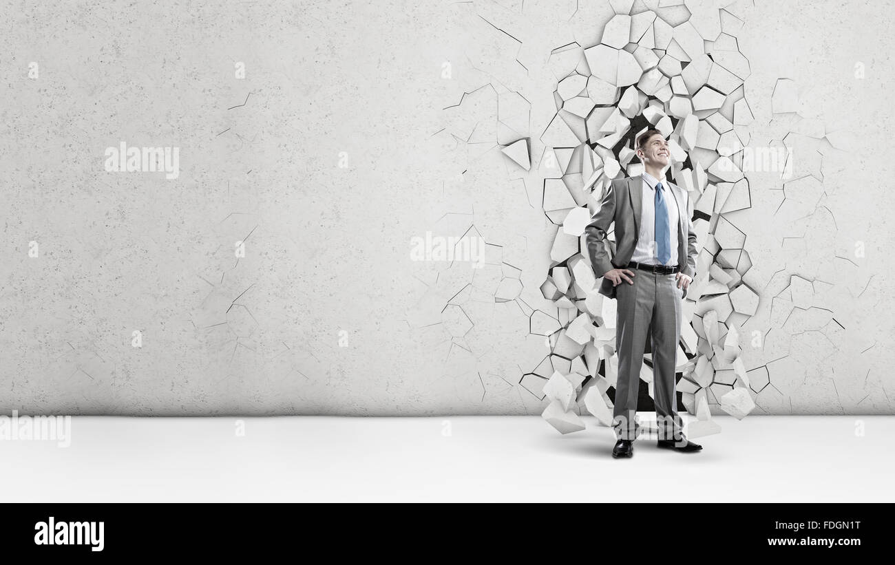 Young powerful businessman breaking through cement wall Stock Photo - Alamy