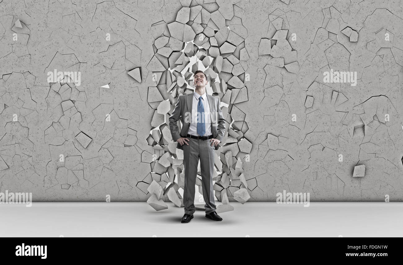 Young powerful businessman breaking through cement wall Stock Photo - Alamy