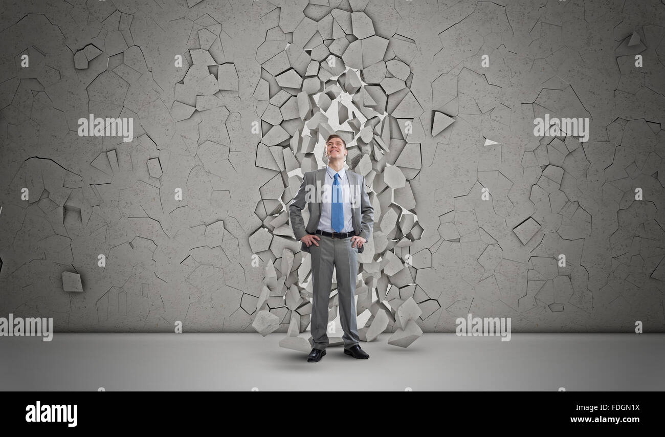 Young powerful businessman breaking through cement wall Stock Photo - Alamy