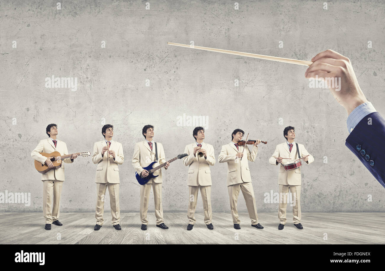 Man orchestra in suit playing different music instruments Stock Photo ...