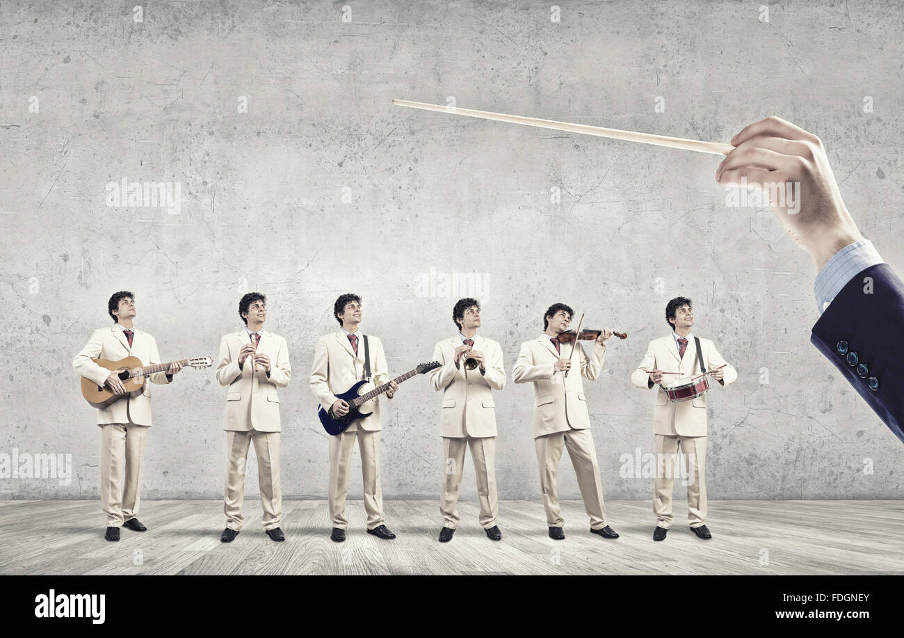 Man orchestra in suit playing different music instruments Stock Photo ...