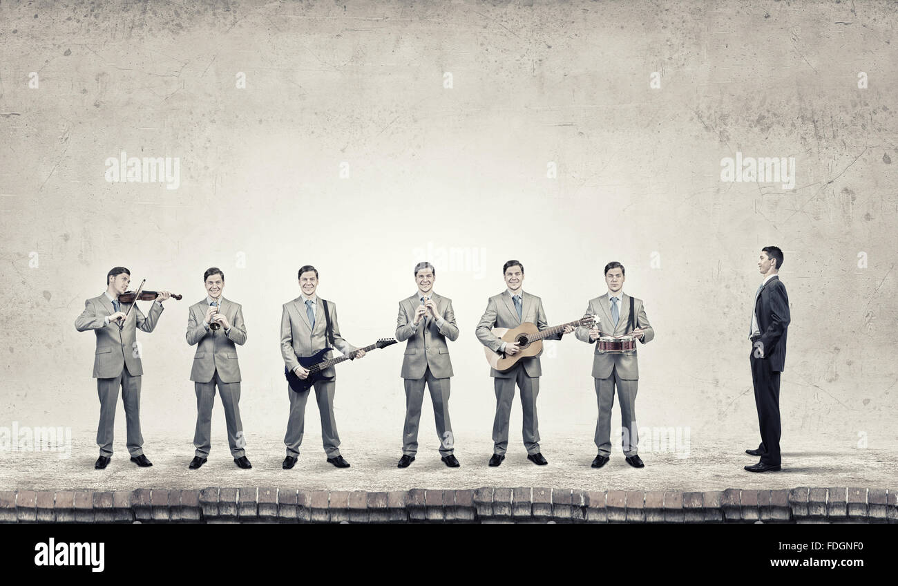 Man orchestra in suit playing different music instruments Stock Photo ...