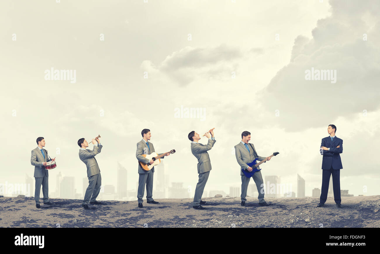 Man orchestra in suit playing different music instruments Stock Photo ...