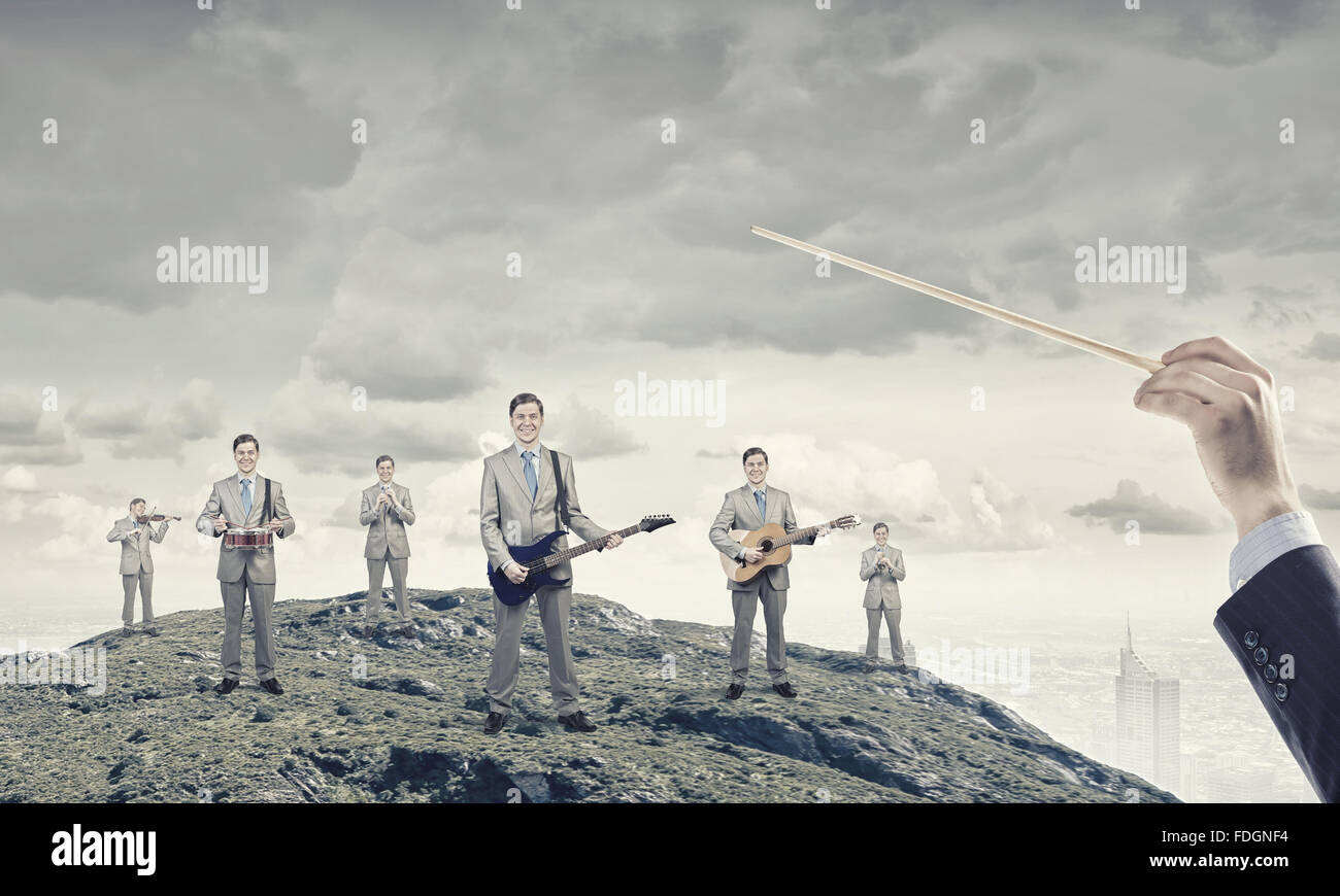 Man orchestra in suit playing different music instruments Stock Photo ...