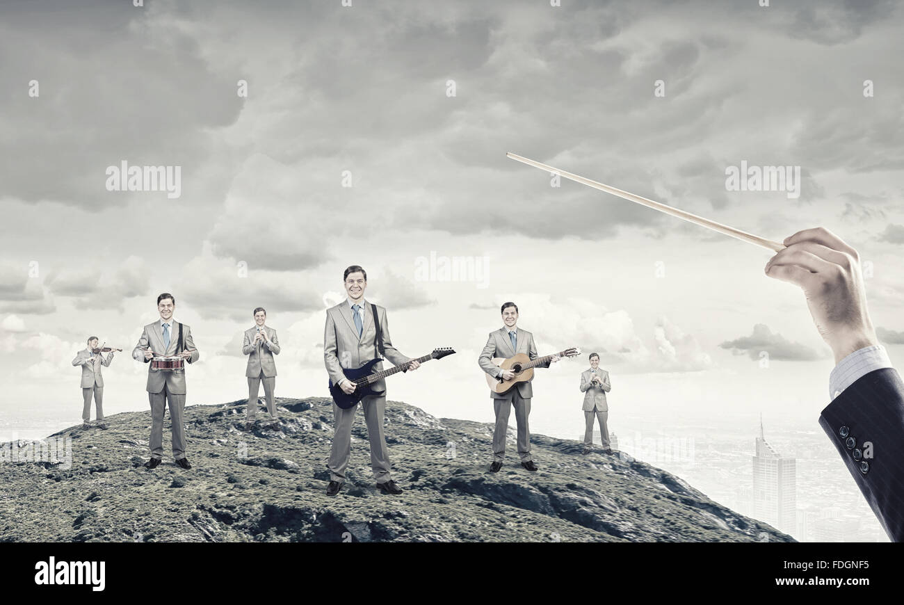 Man orchestra in suit playing different music instruments Stock Photo ...
