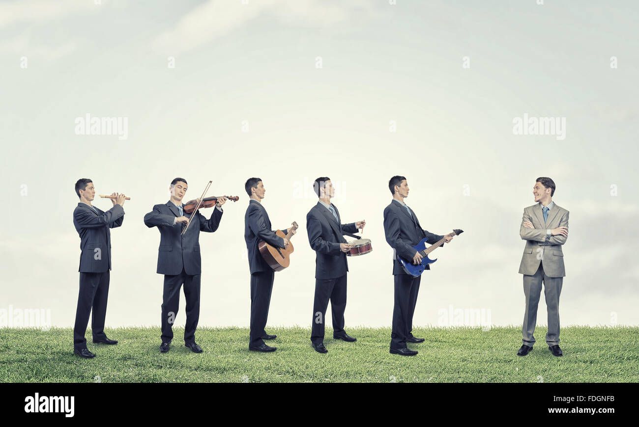 Man orchestra in suit playing different music instruments Stock Photo ...
