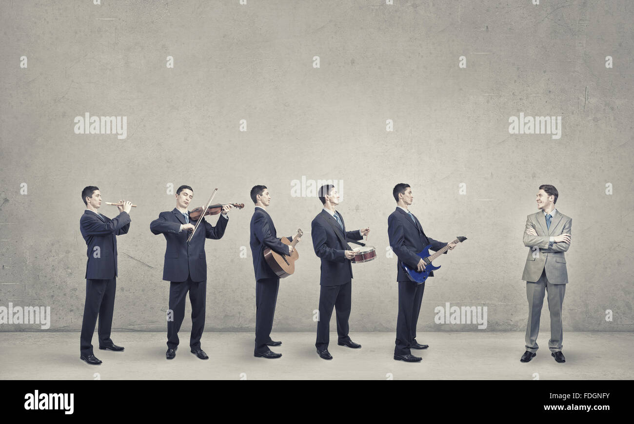 Man orchestra in suit playing different music instruments Stock Photo ...