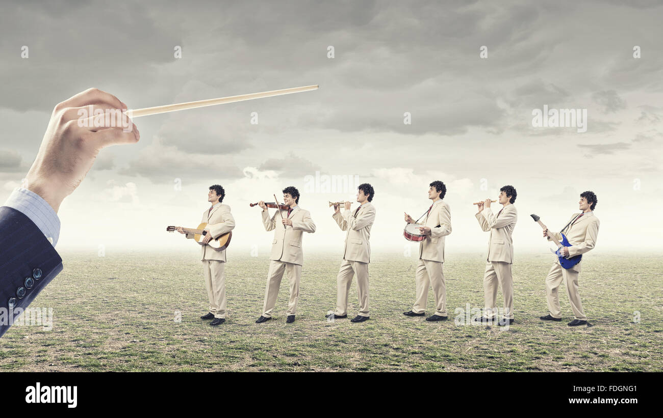 Man orchestra in suit playing different music instruments Stock Photo ...
