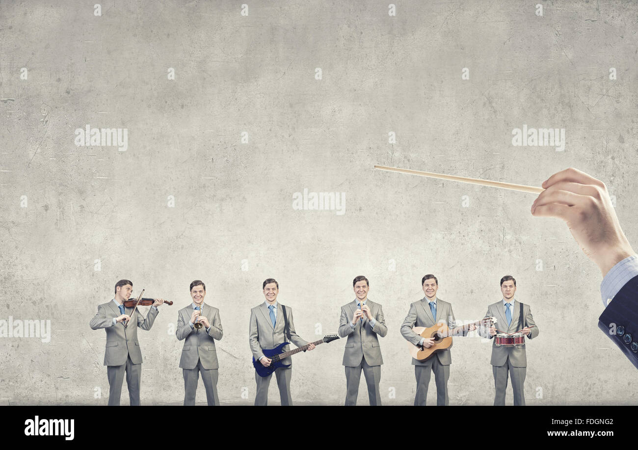 Man orchestra in suit playing different music instruments Stock Photo ...