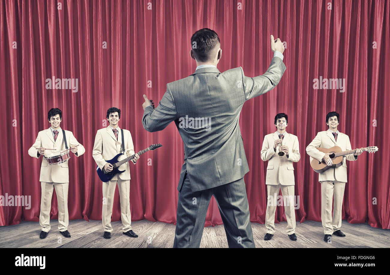 Man orchestra in suit playing different music instruments Stock Photo ...