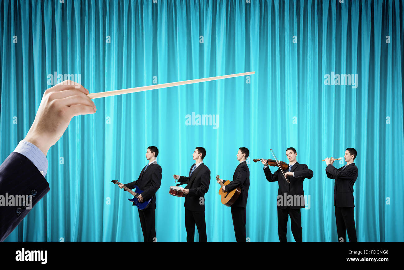 Man orchestra in suit playing different music instruments Stock Photo ...