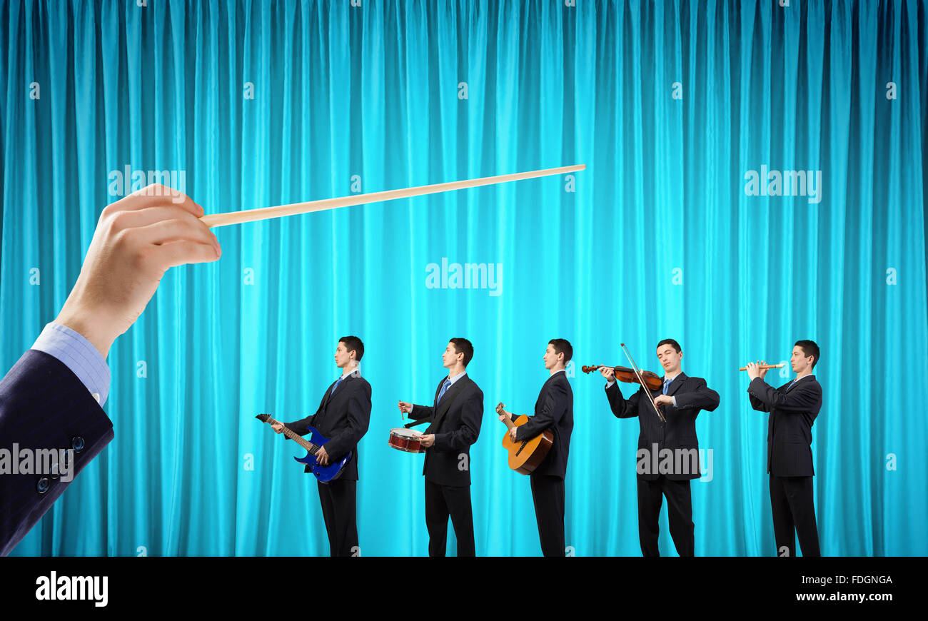 Man orchestra in suit playing different music instruments Stock Photo ...