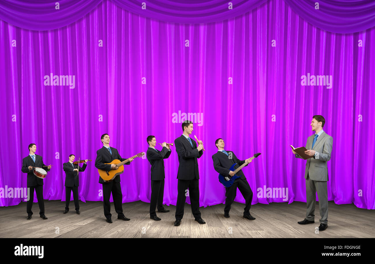 Man orchestra in suit playing different music instruments Stock Photo ...