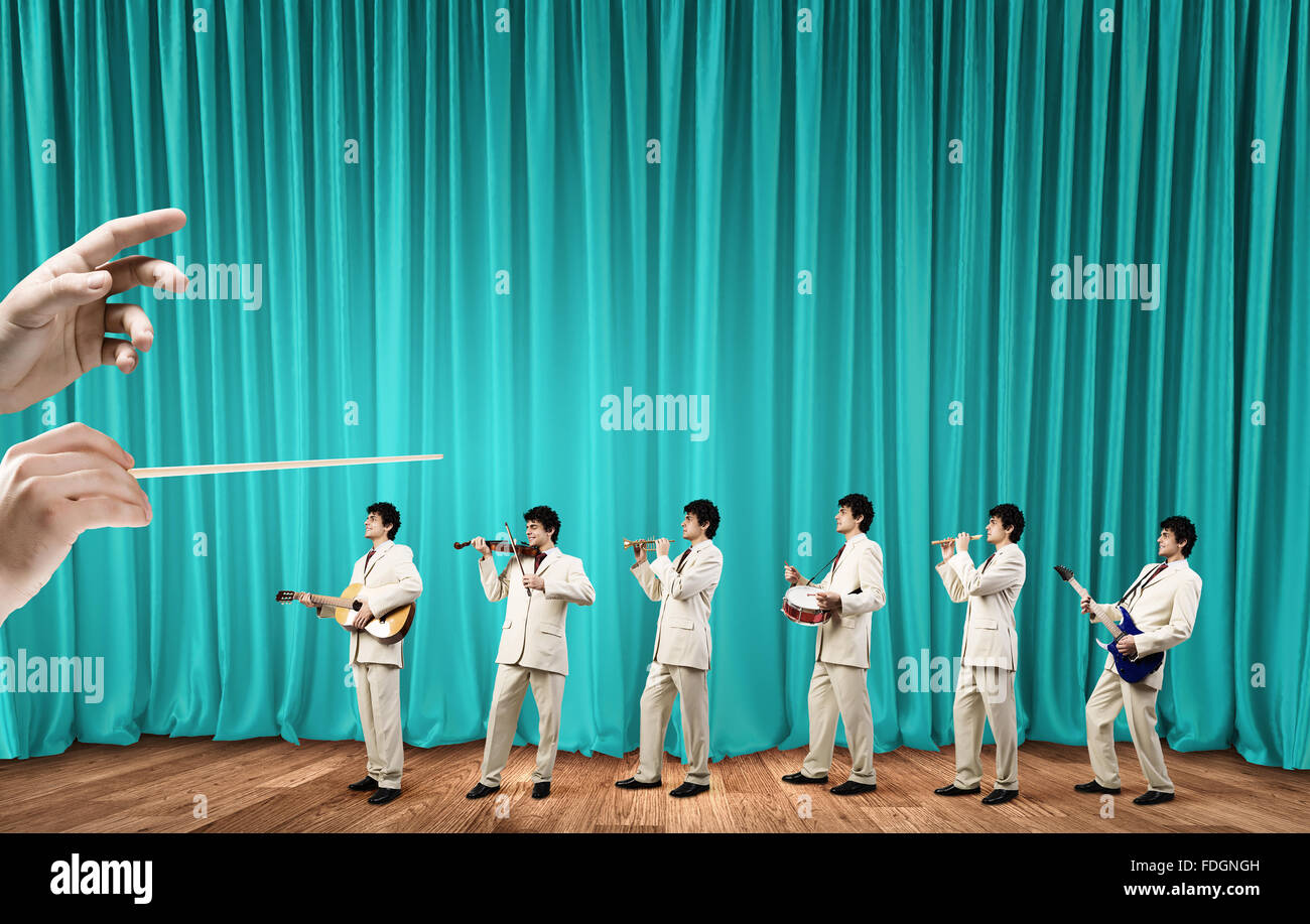 Man orchestra in suit playing different music instruments Stock Photo ...