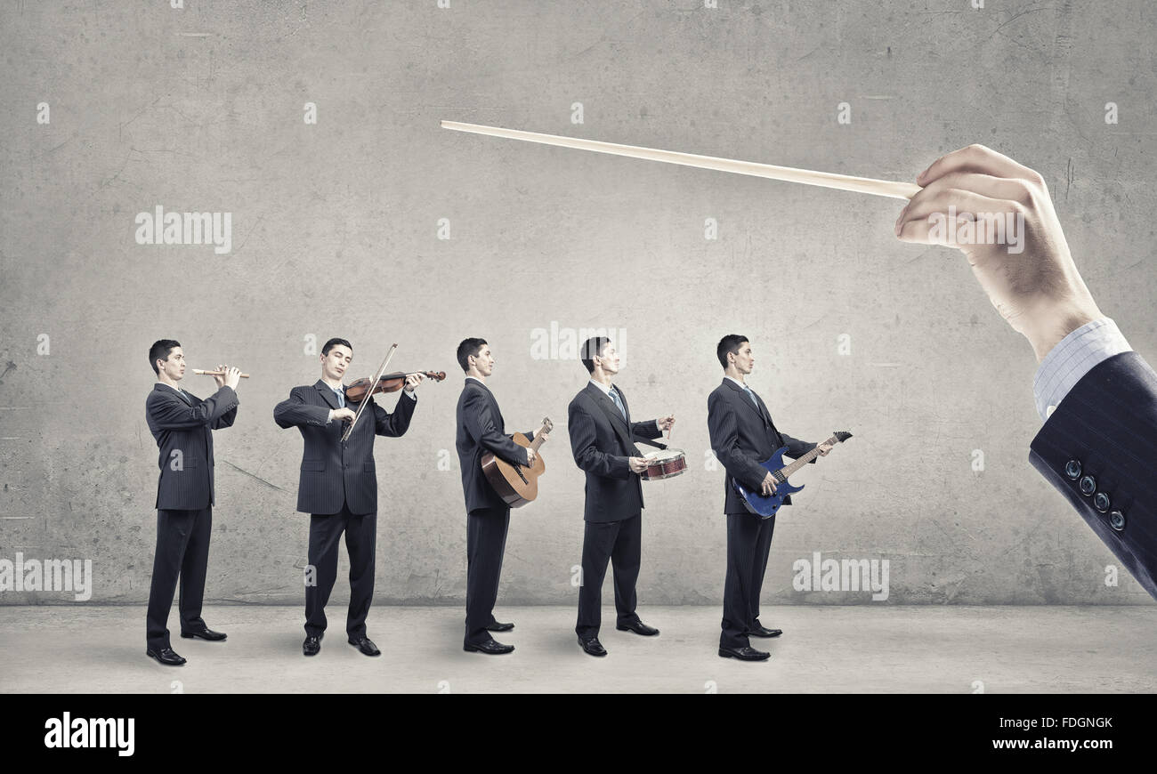 Man orchestra in suit playing different music instruments Stock Photo ...